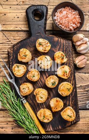 BBQ Seared scallops with butter sauce on a wooden board. wooden ...