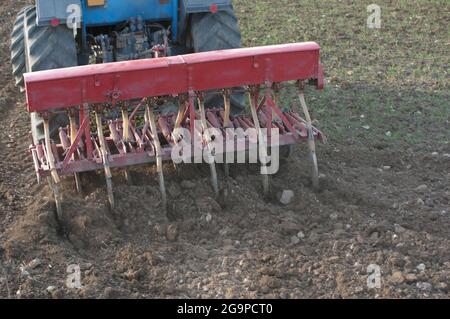 Rear closeup view of a articulated tractor with multiple plows that is ...