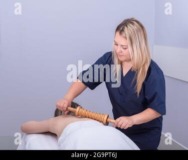 The masseur does a massage using anti-cellulite massage machine with ...