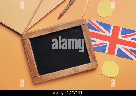 Stationery, chalkboard and UK flag on color background. Concept of ...