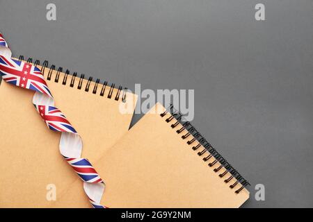 Notebooks and ribbon in colors of UK flag on grey background. Concept ...