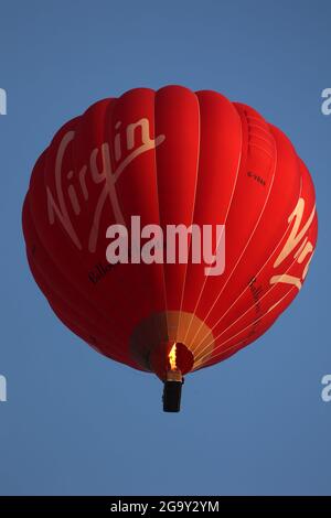 Peterborough, UK. 26th July, 2021. A red Virgin hot air balloon flies ...