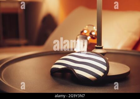Stylish sleeping mask on table in bedroom Stock Photo - Alamy