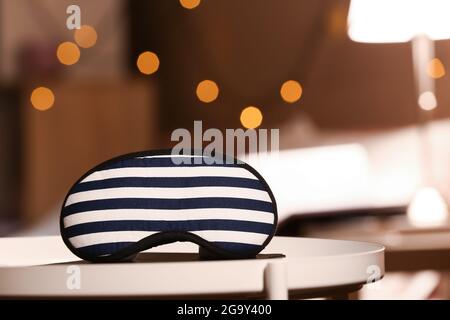 Stylish sleeping mask on table in bedroom Stock Photo - Alamy