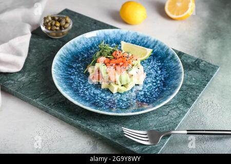 Delicious salmon tartar on grunge background, closeup Stock Photo - Alamy