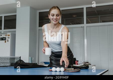 Young employee drinking coffee at workplace Stock Photo - Alamy