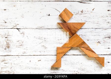 Tangram puzzle in happy running man shape on old white wood background ...