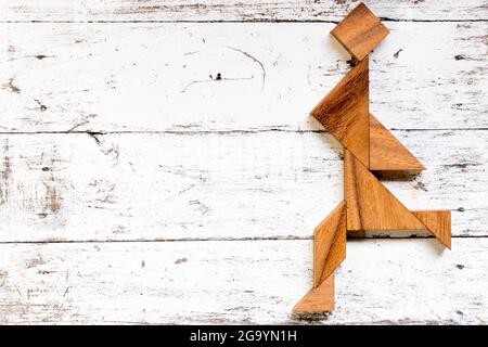 Tangram puzzle in happy running man shape on old white wood background ...