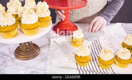 Arranging pumpkin spice cupcake decorated with Italian buttercream ...