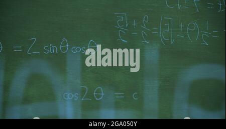 Mathmatical equations written in chalk rising from green chalkboard ...