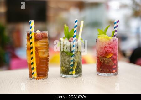 Cups of iced cocktail with paper straws on the table Stock Photo - Alamy