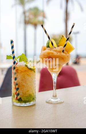 Cups of iced cocktail with paper straws on the table Stock Photo - Alamy