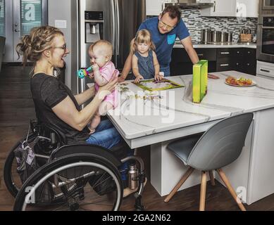 A paraplegic mother in a wheelchair playing with her baby in a baby ...