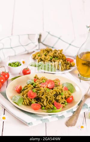 Fusilli pasta with cherry tomatoes and peas Stock Photo - Alamy