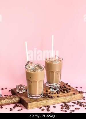 Glasses with cold brew and coffee beans on pink background Stock Photo ...