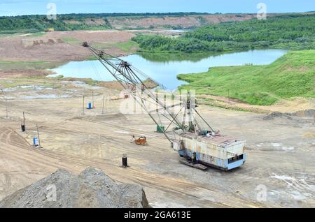 Large dragline excavator working in an open‑pit mine under clear blue ...