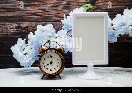 Blank Display frame stand and alarm clock on wooden background Stock ...