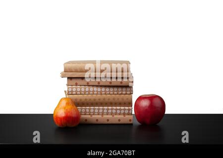 Stack of books and apple on tabletop against white background Stock ...