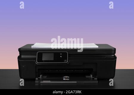 Home laser printer on desk against purple background Stock Photo - Alamy