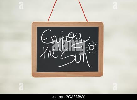 Wooden framed small blackboard with a "Beach Day" writing on the sandy ...