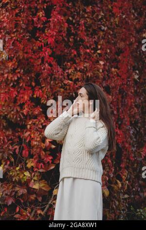 Young woman in red sweater reading book on white background Stock Photo ...