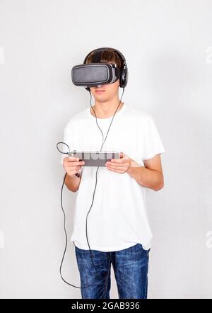Virtual reality glasses and tablet with headphones on a gray background ...