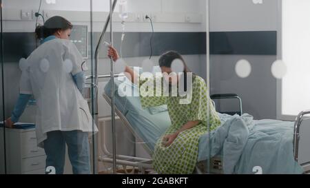 Black asisstant with practitioner doctor helping patient to stand up ...