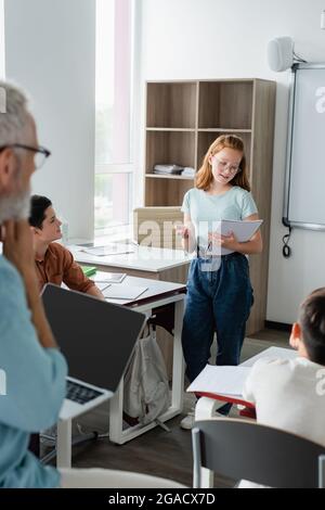 Boys and girls pupils talking near the notebook in the math class Stock ...