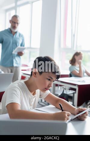 Boy with girl are writing in notebook their homework Stock Photo - Alamy