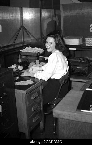 1940s SMILING YOUNG WOMAN SECRETARY TYPIST SITTING BEHIND OFFICE ...