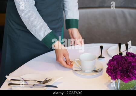 Waiting staff prepare a table in a restaurant Stock Photo - Alamy
