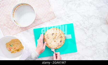 Flat lay. Step by step. Wrapping freshly baked funfetti cake into ...