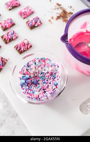 Drizzling melted pink chocolate on top of the mini chocolates and ...