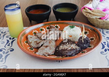 Roast beef with rice, mole poblano and refried beans, traditional ...