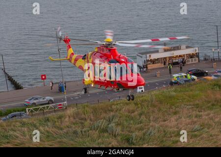 Air Ambulance helicopter hovers near a ground ambulance at Lossiemouth ...