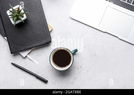 Notebooks with laptop and houseplant on light background Stock Photo ...
