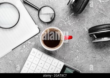 Cup of coffee, magnifiers, calculator and notebook on grunge background ...