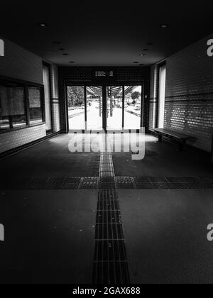 Long hall with exit at the end Stock Photo - Alamy