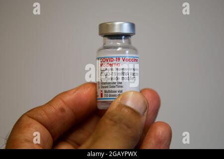 A health worker holds a Moderna Covid-19 vaccine vial at a vaccination ...