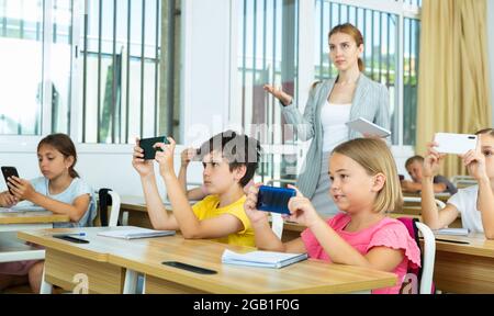 Pupils using mobile phones during lesson in school Stock Photo - Alamy