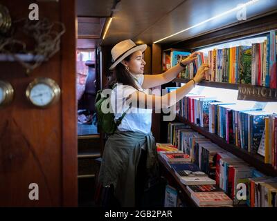 A customer browsing at Word On The Water, aka The London Bookbarge, a ...