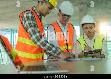 Group of engineers and architectures planning and checking building ...