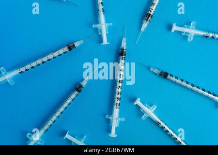 medical syringes on blue background Stock Photo - Alamy