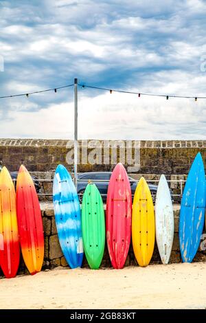 Colourful surfboards, canoes and kayaks at Mousehole Harbour, Mousehole ...