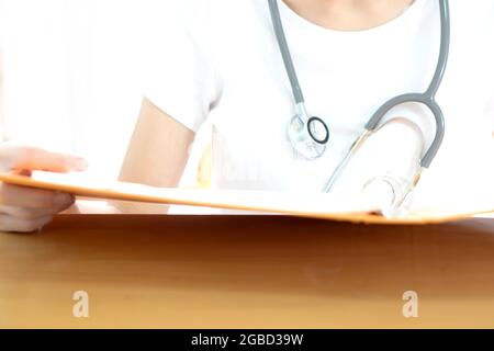 Asian female doctor reading medical textbook studying research at ...