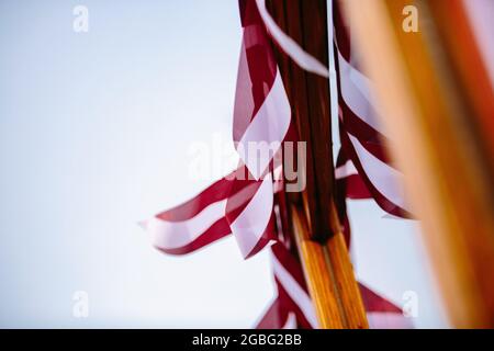 Closeup shot of tiny triangle flags of Latvia on the roof of the wooden ...