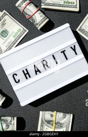Lightbox board with word CHARITY in black letters around US dollar ...