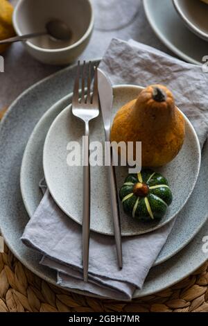 Autumn table setting and pumpkins on grey background Stock Photo - Alamy