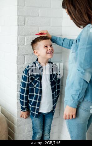 son mother measuring height growth childhood tall child heigth kid wall ...