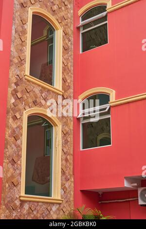 Salmon-colored hotel facade with symmetrical windows Stock Photo - Alamy
